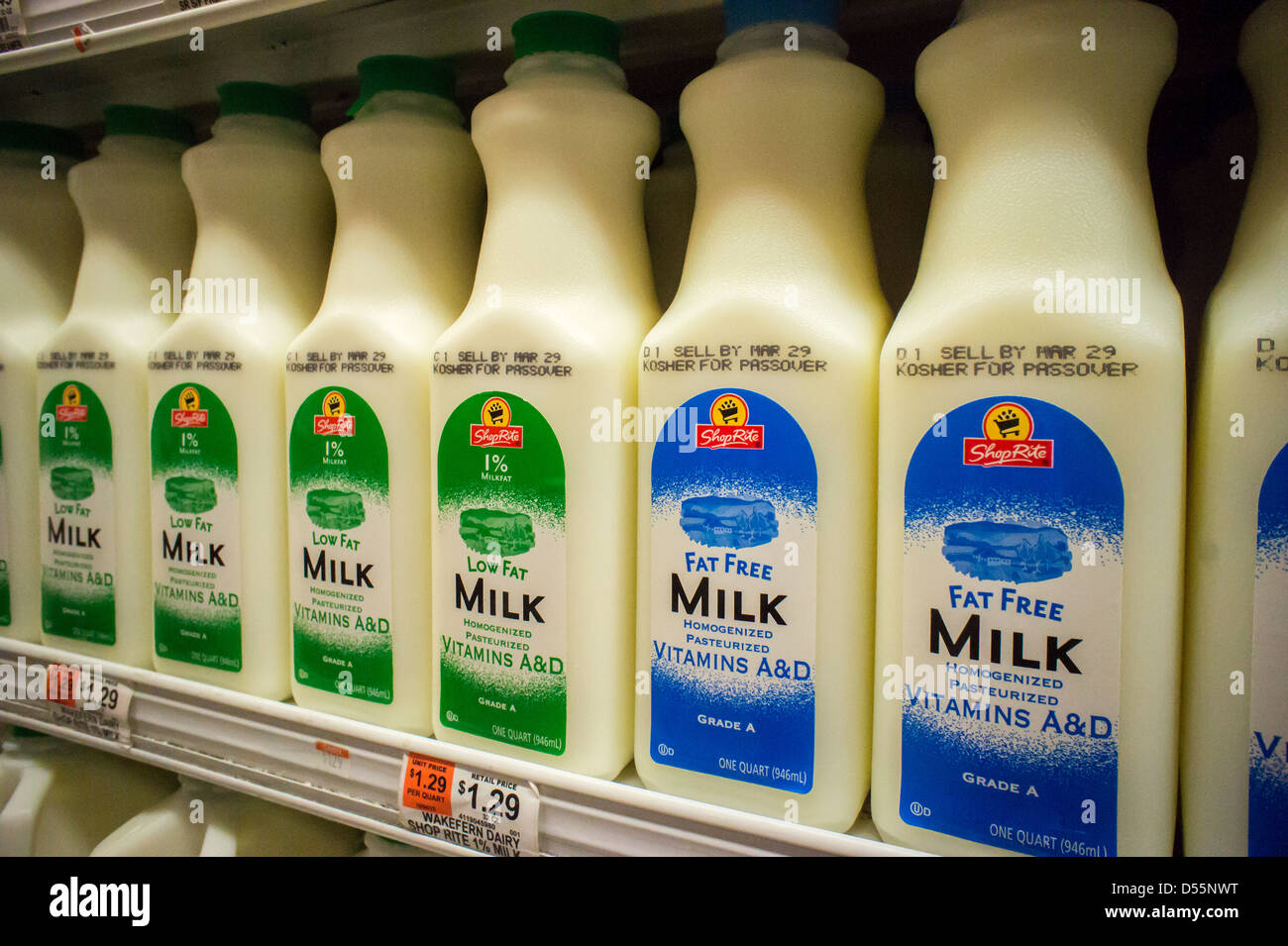 Containers of fat free and low fat milk in a supermarket refrigerator ...