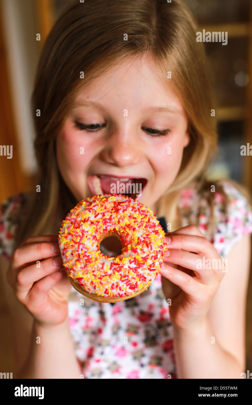 Young girl eating a Donut Stock Photo - Alamy