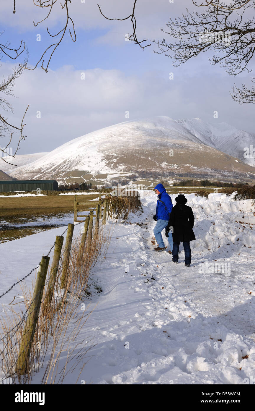 Walkers trudge through snow drifts on a lane towards Blencathra , Lake ... Walkers trudge through snow drifts on a lane towards Blencathra , Lake ...