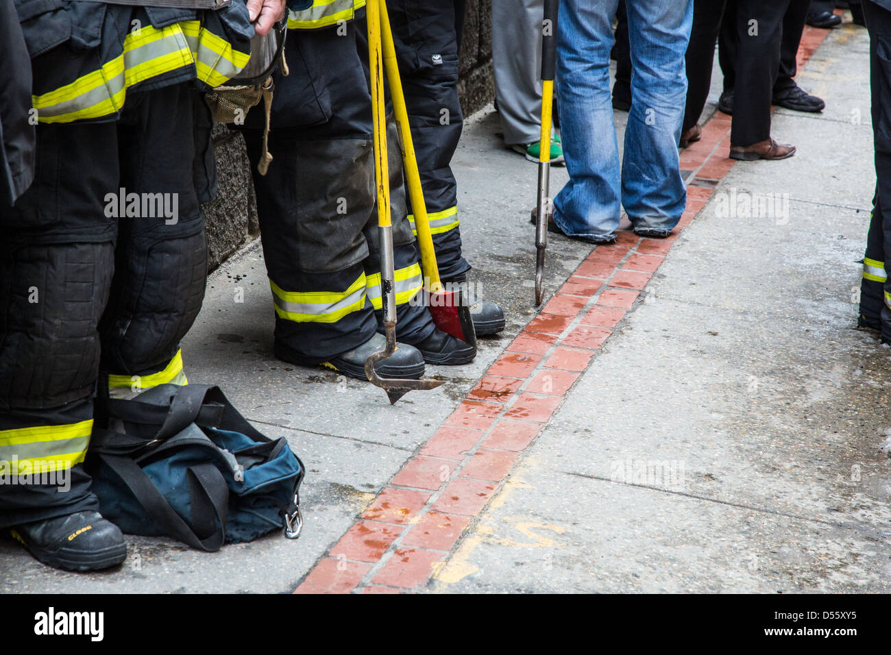 Firemen stand around waiting for an all clear at a hotel fire alarm ...