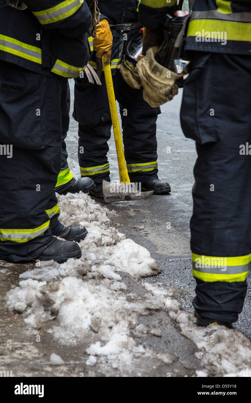 Firemen stand around waiting for an all clear at a hotel fire alarm ...