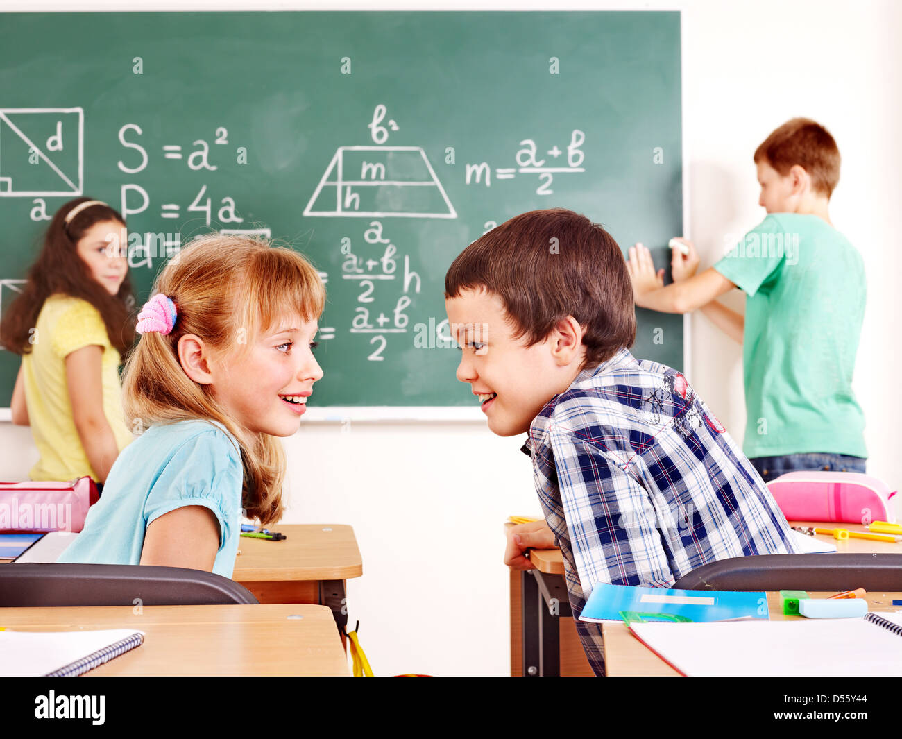 School child sitting on desk in classroom Stock Photo - Alamy