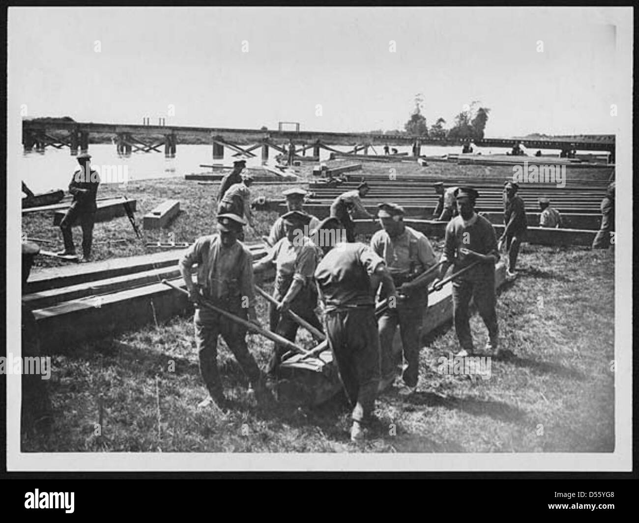Royal Engineers (R.E.) are shown constructing a railway bridge over a ...