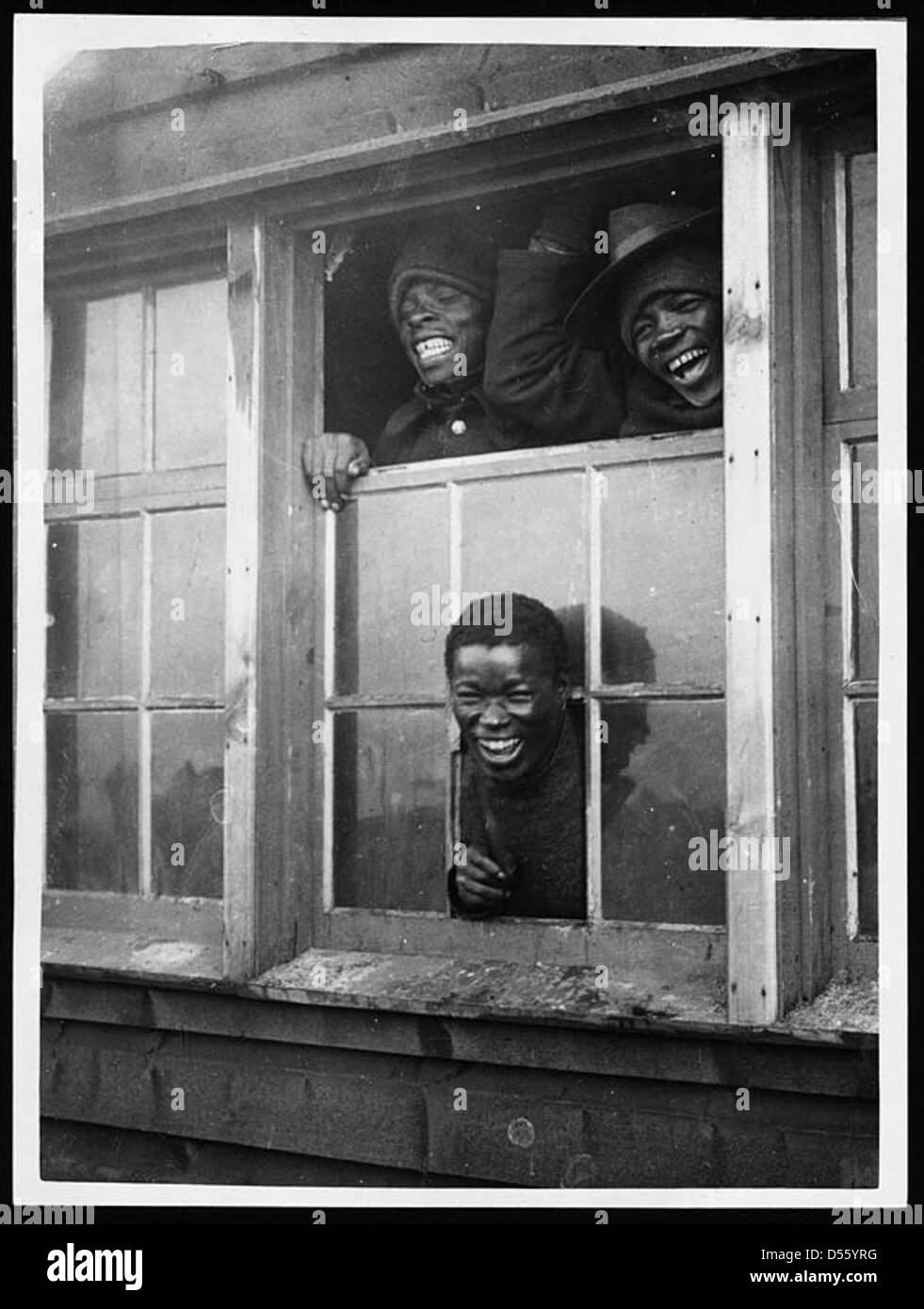 A soldier peers out from the window of a captured German hut ...