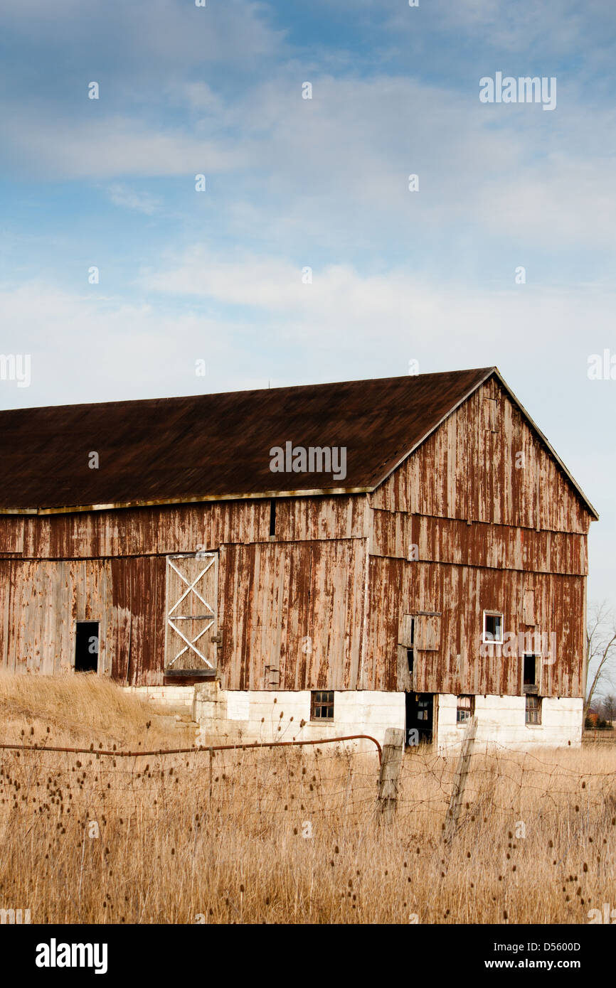 An old weathered bank barn with fields in the foreground A blue sky ...