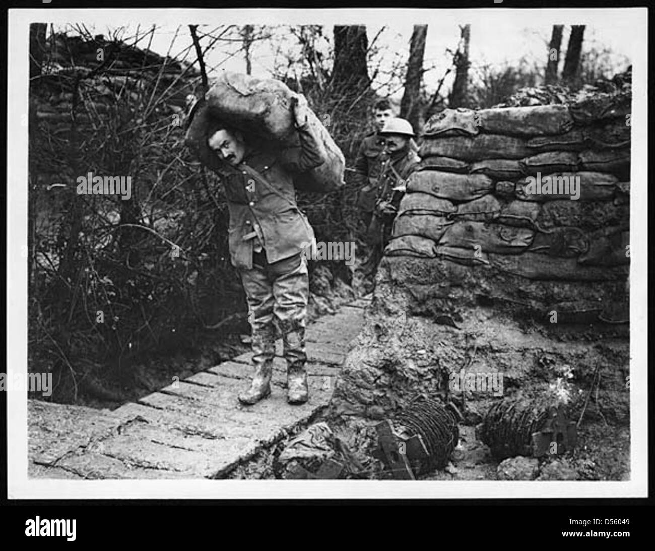 Soldiers carrying heavy loads of sandbags to the front line during ...