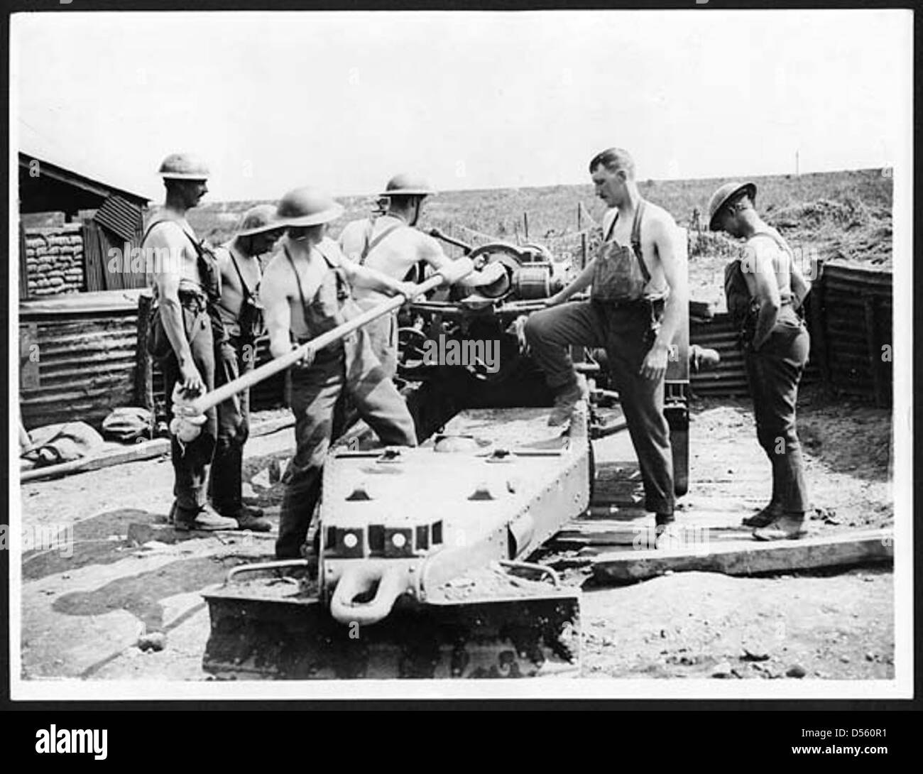 A soldier is captured in the moment of loading a shell into a cannon ...