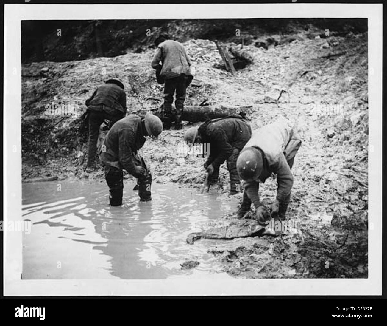Soldiers, referred to as 'Tommies', clean their trench waders ...