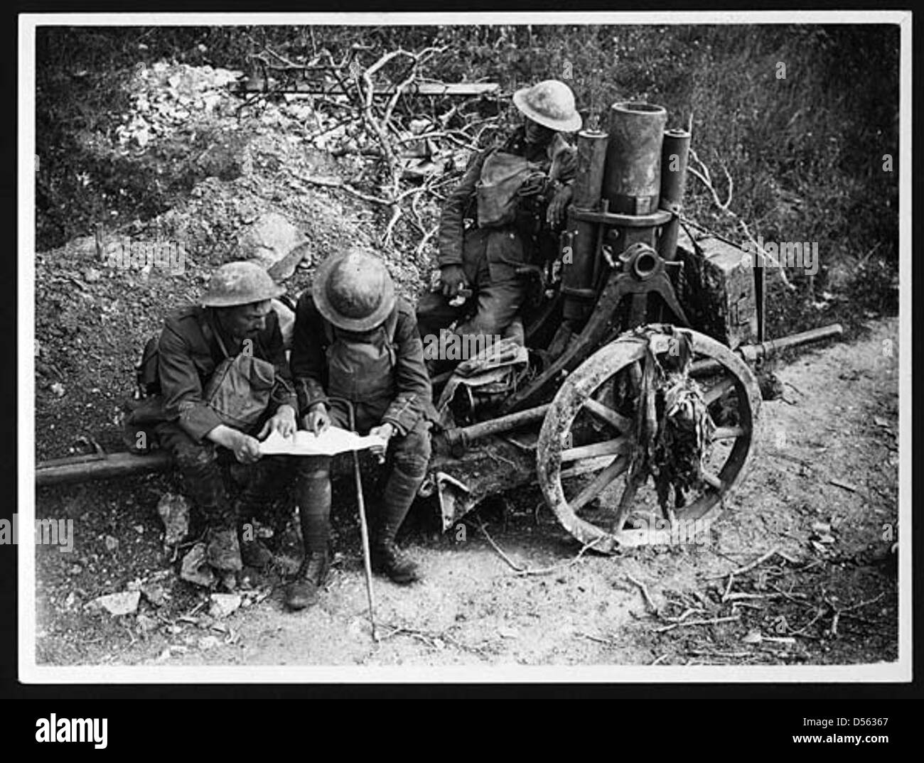Two officers are seen reviewing a map while sitting on a large captured ...