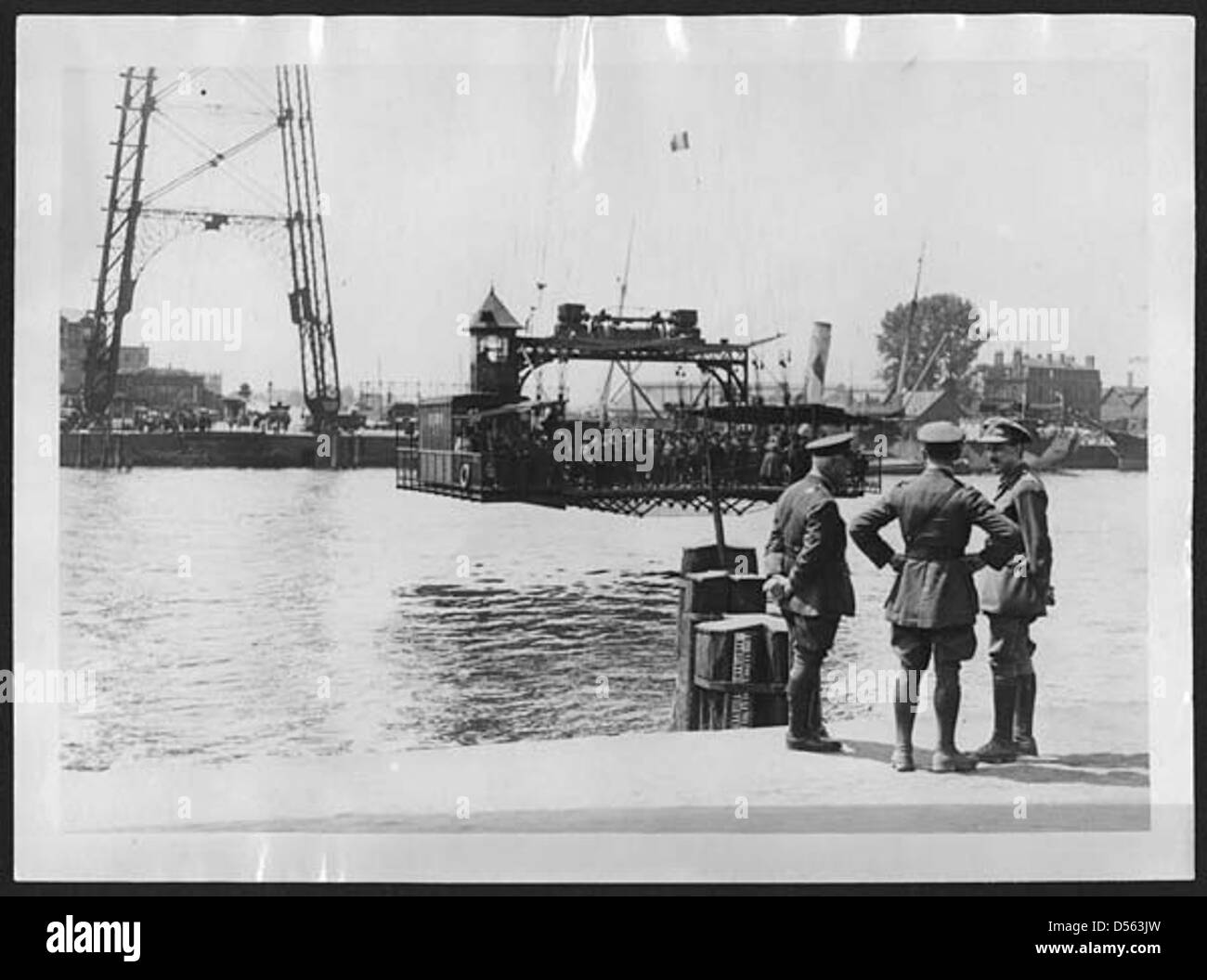 A bridge suspended by cables crosses a river, likely used for military ...