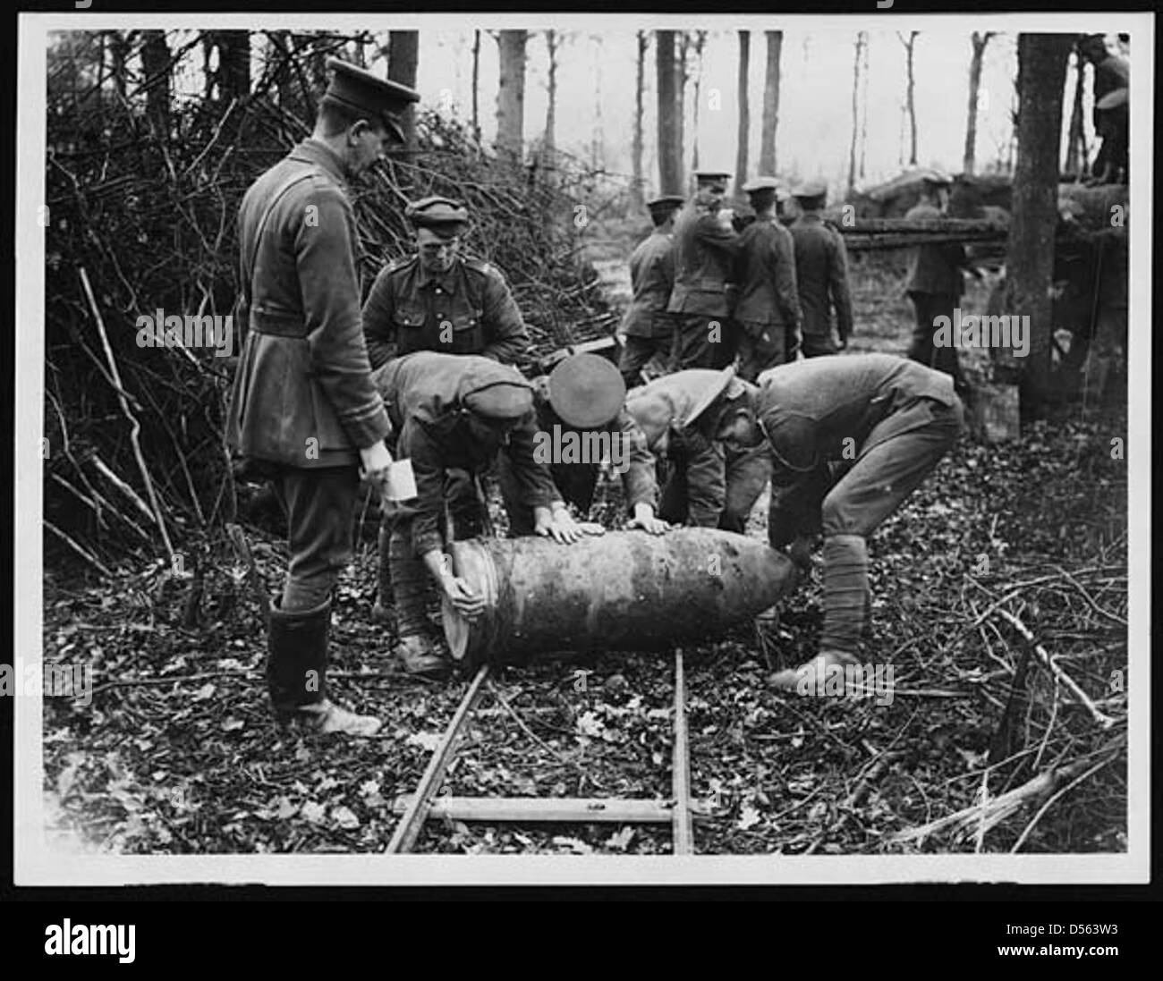 A soldier rolls a massive shell to the gun, illustrating the scale of ...