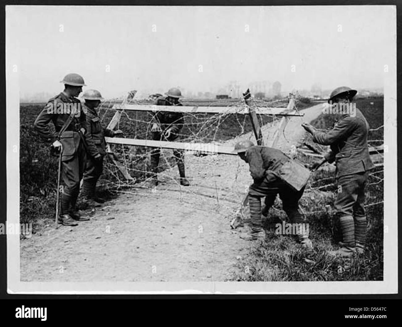 Engineers are shown wiring a road during World War I, preparing it for ...