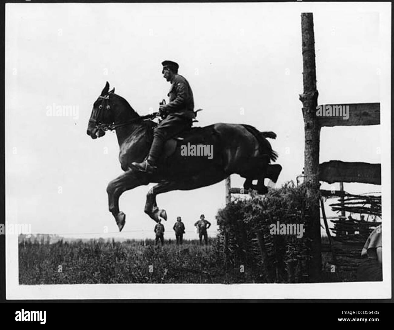 A soldier on horseback leads a group of cavalry in a jump during World ...