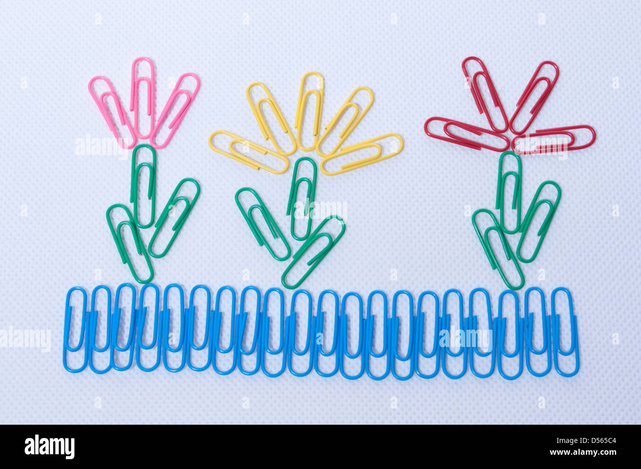 the three flowers with color paper clips on the white background Stock ...