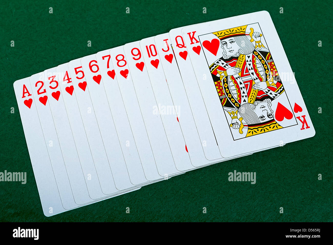 Playing cards red deck on the green background Stock Photo - Alamy