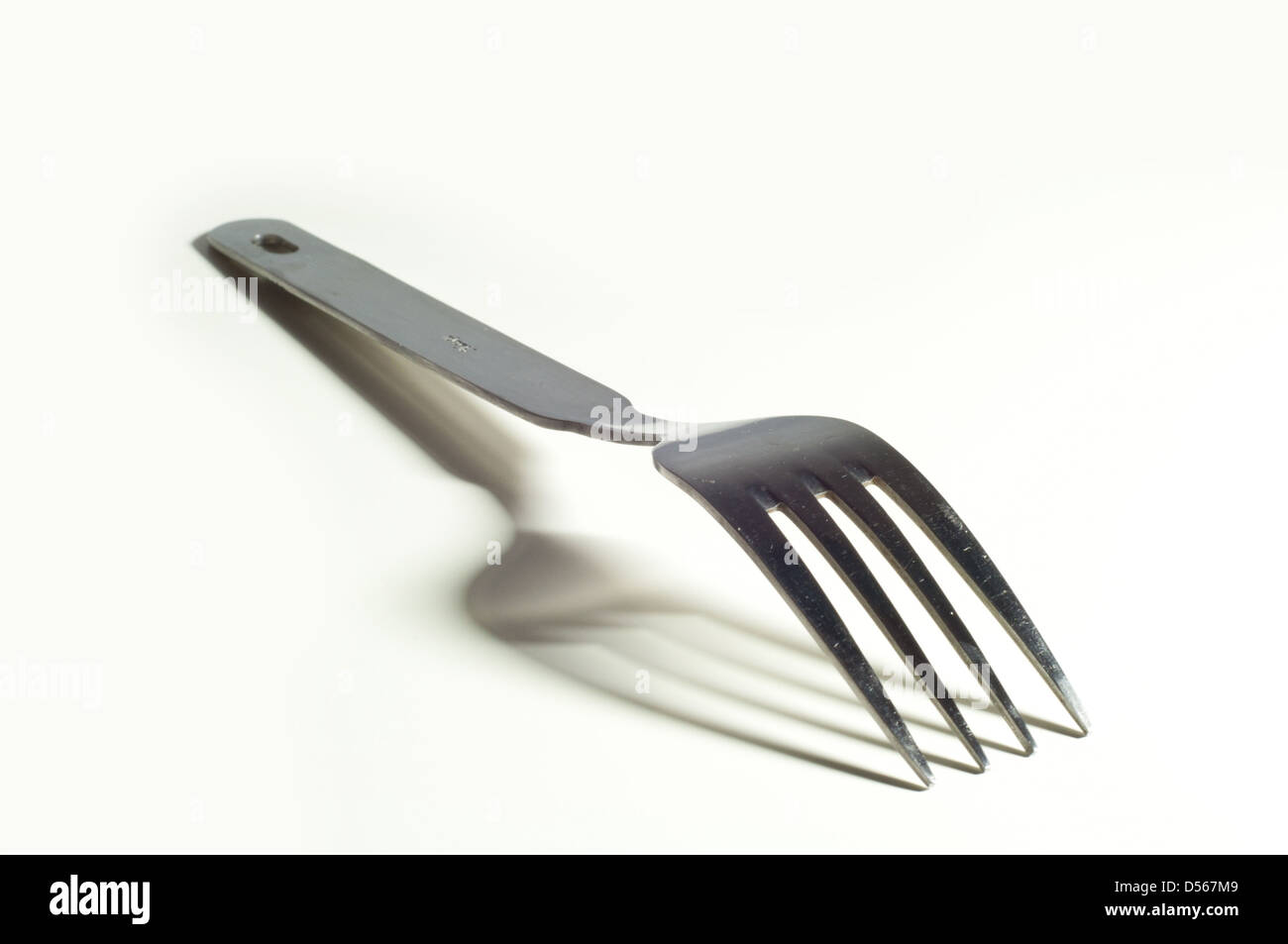 metallic fork and her shadow on the white background Stock Photo - Alamy
