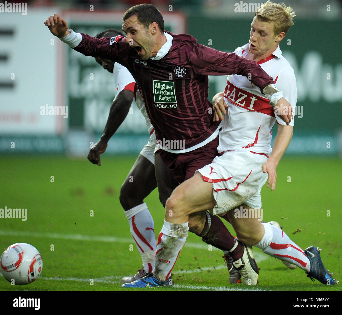 Stuttgart's Patrick Funk (R) and Arthur Boka (L) tackle Kaiserslautern ...