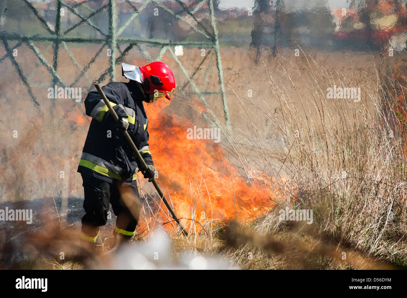 Firemen beating out a grass fire Stock Photo - Alamy