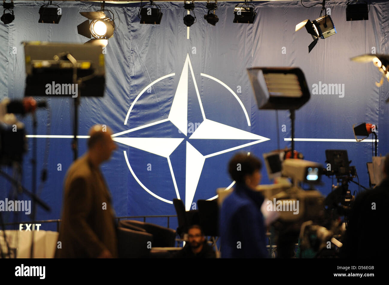 A NATO insignia is surrounded by lights and cameras at the press centre ...