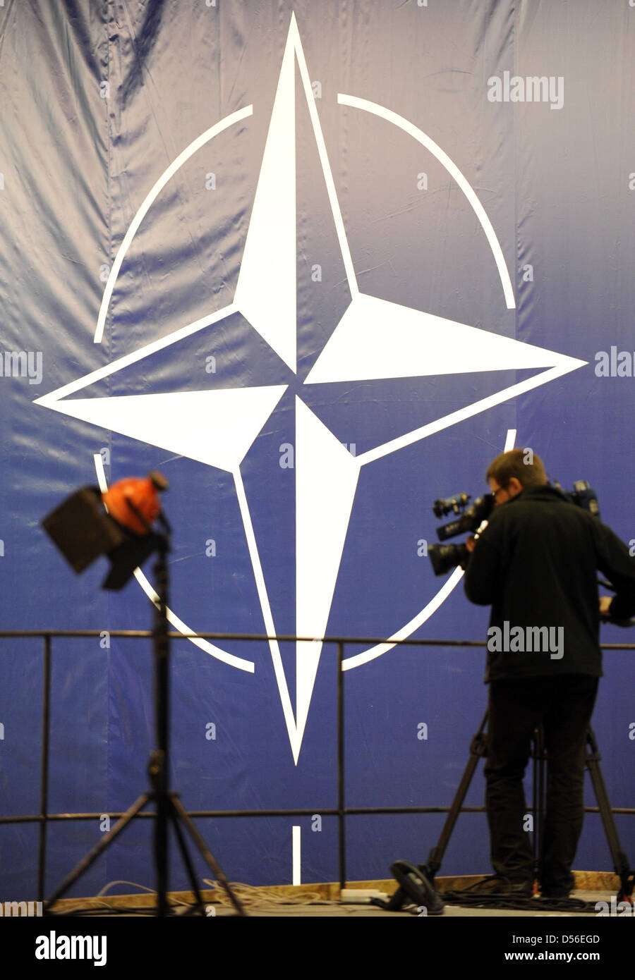 A NATO insignia is surrounded by lights and cameras at the press centre ...