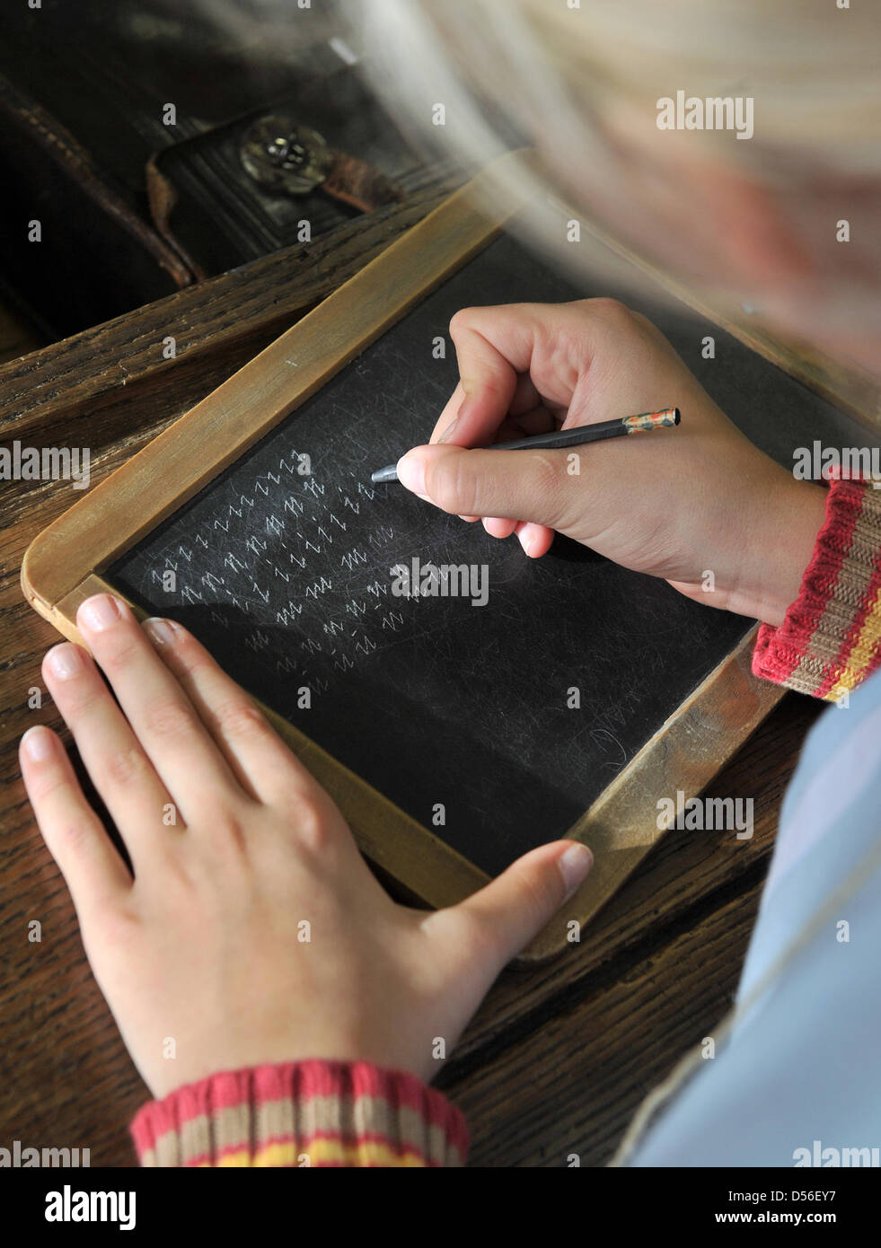 A pupil writes on a slate in a historical class room of Ebersdorf ...