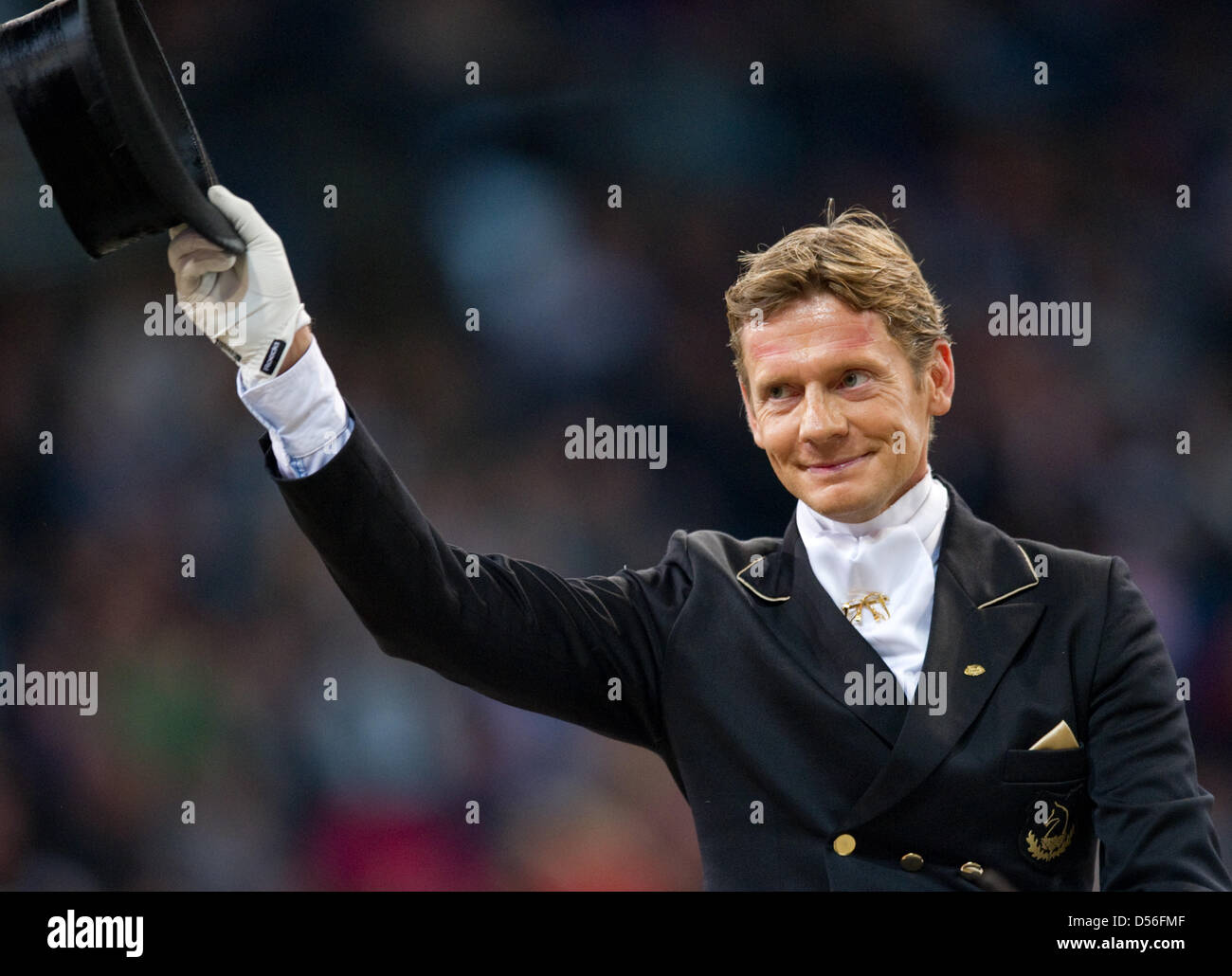 Dutch dressage rider Edward Gal tips his hat to the crowd during the ...