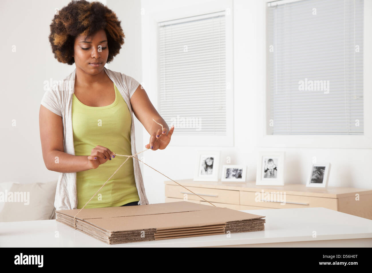 African American woman wrapping flat cardboard boxes Stock Photo - Alamy