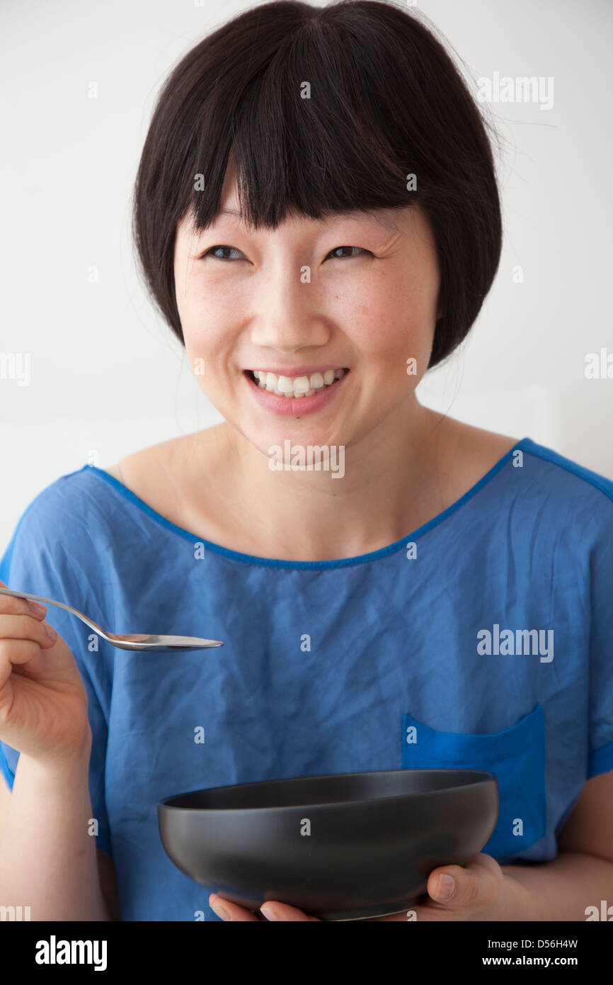 Smiling Chinese woman eating Stock Photo - Alamy