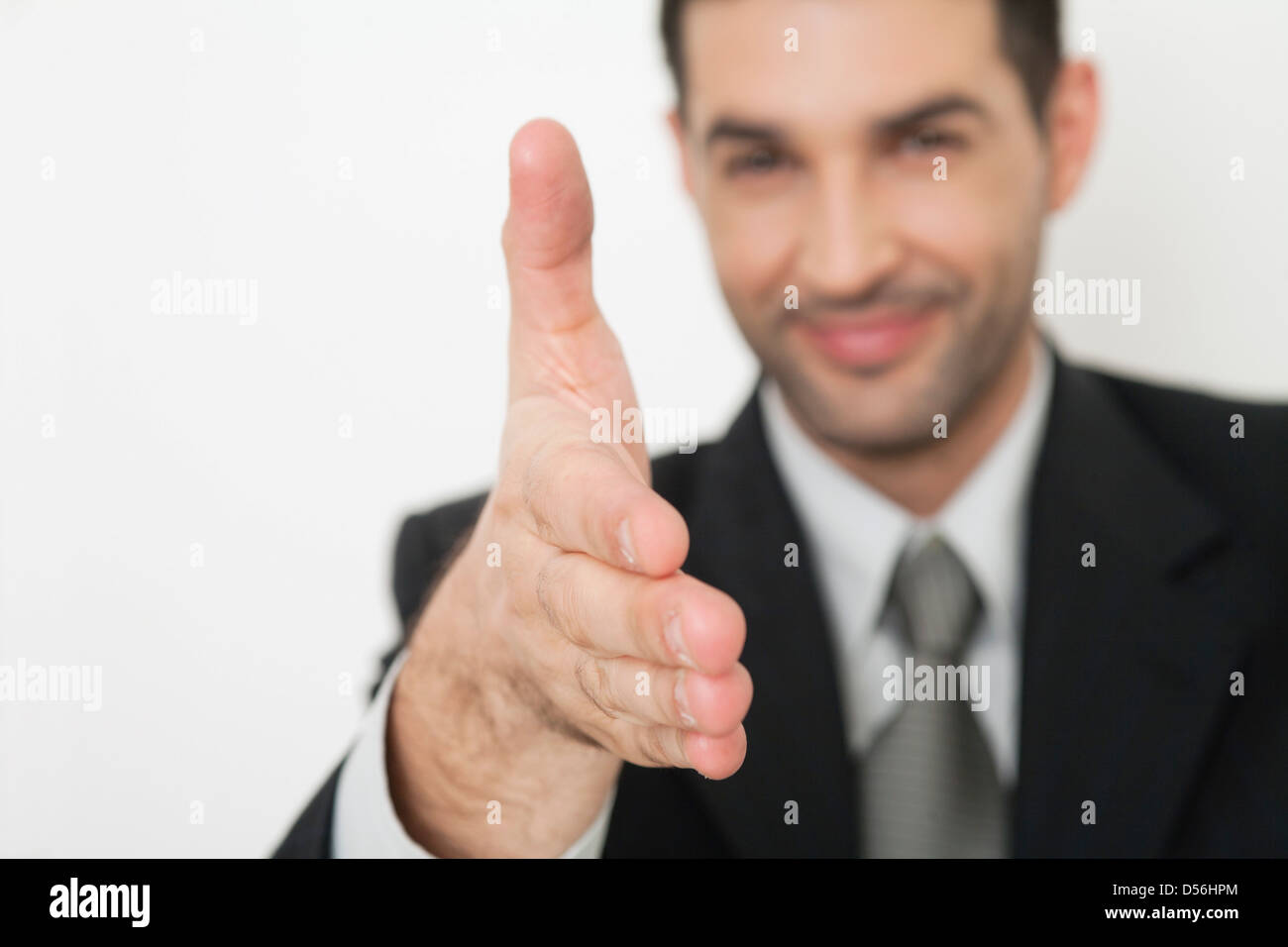 Mid-adult businessman extending hand for handshake Stock Photo - Alamy