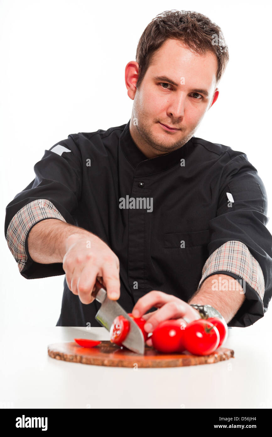 Young male cook with black jacket preparing raw ingredients isolated on ...
