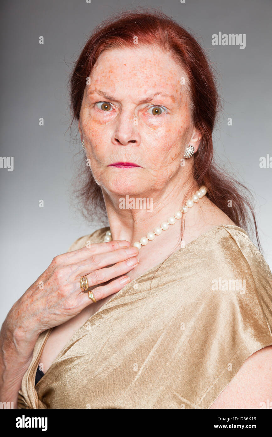 Portrait of good looking senior woman with expressive face showing ...