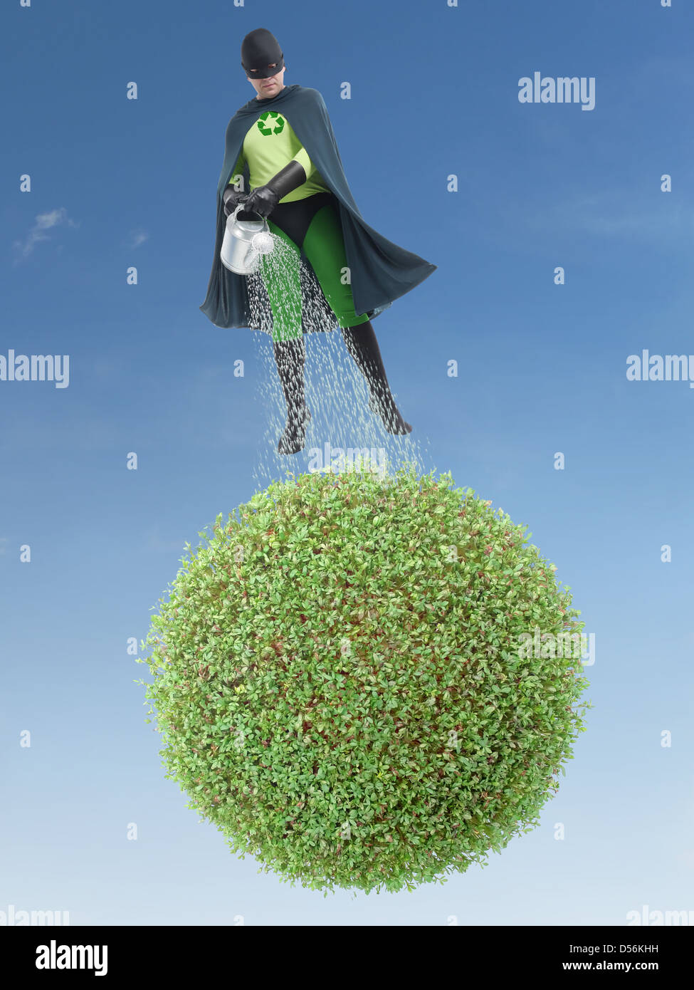 Eco superhero watering green planet from above - green environment ...