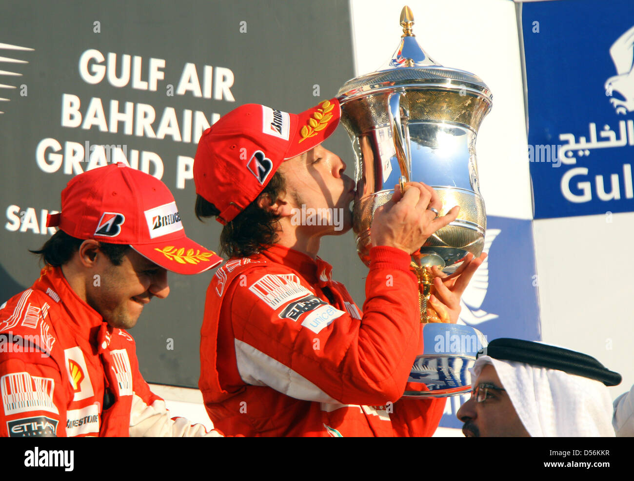Winner Spanish Fernando Alonso (R) of Ferrari kisses the trophy next to ...