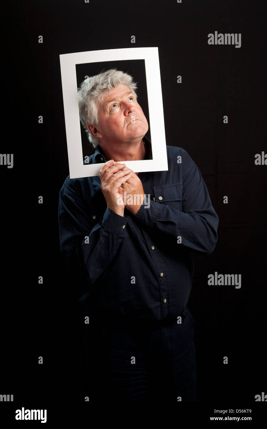 Self portraits, male looking through a white frame on a black ...