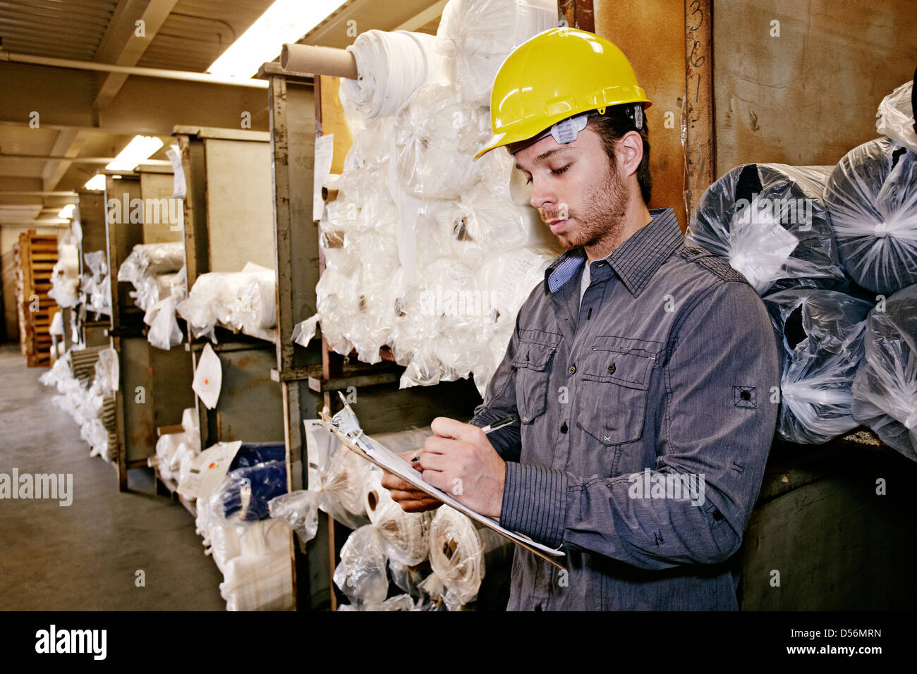 Caucasian worker checking product in warehouse Stock Photo - Alamy