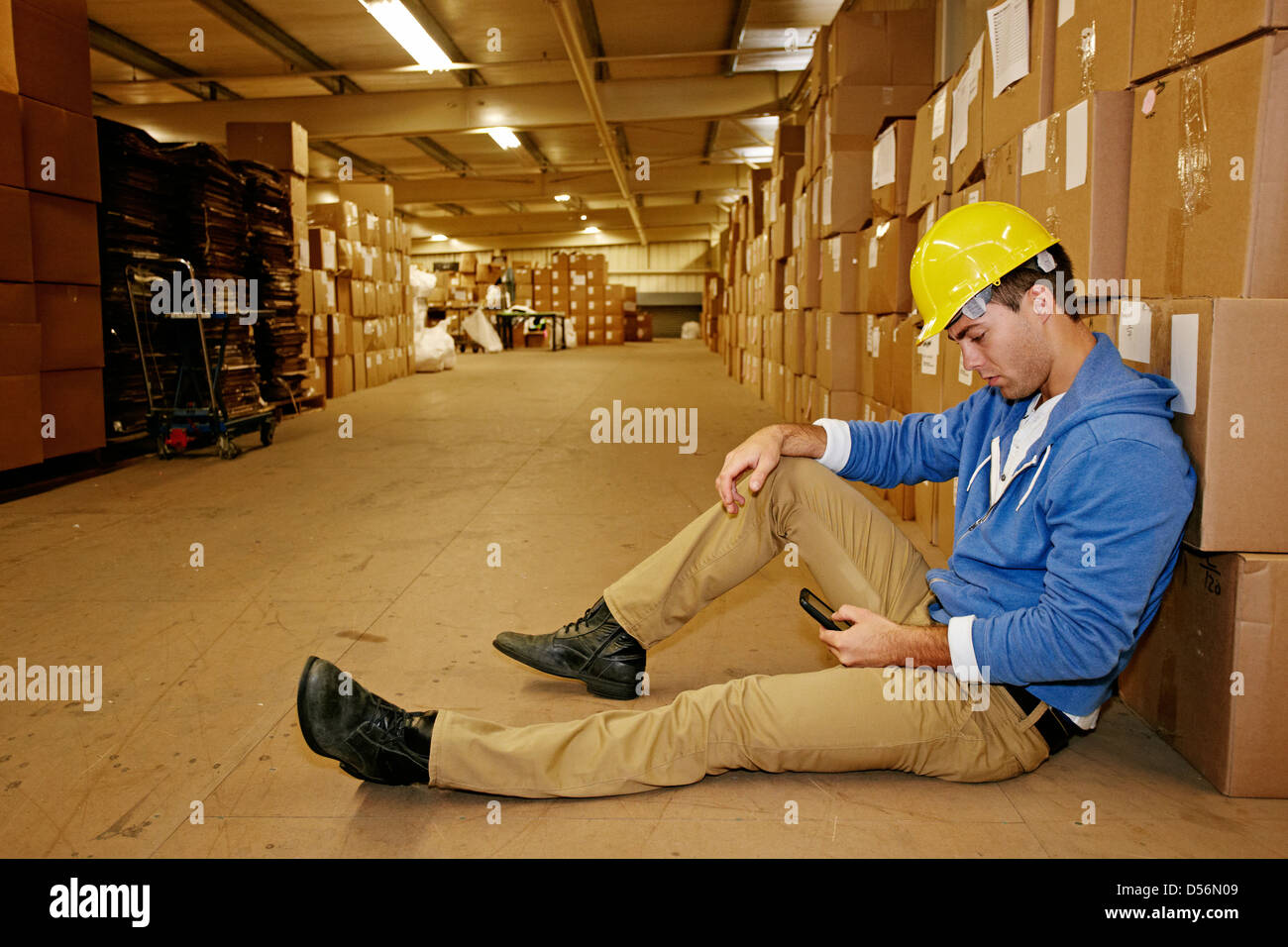 Caucasian worker using cell phone in warehouse Stock Photo - Alamy