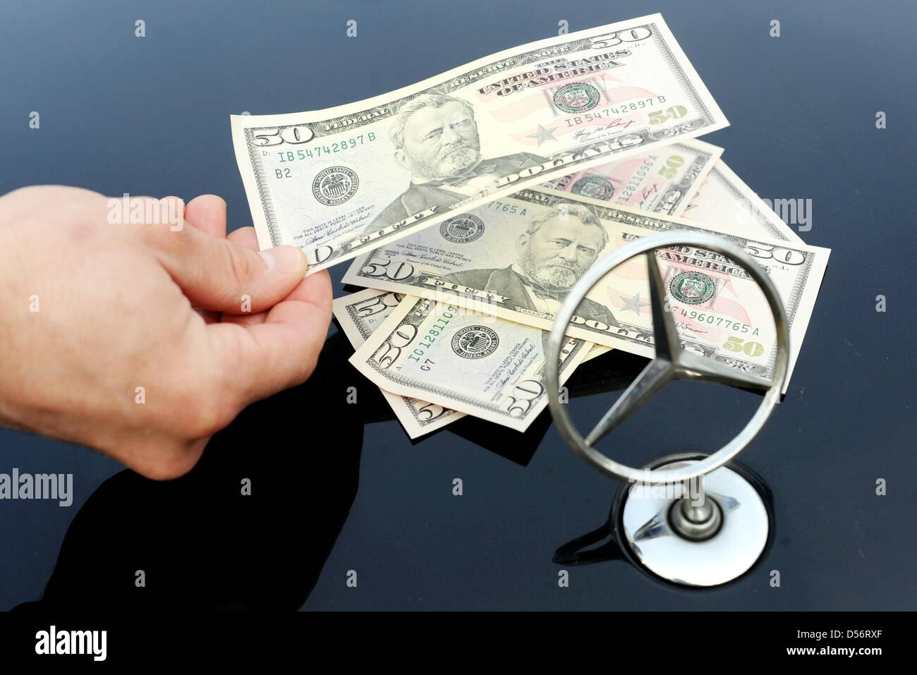 ILLUSTRATION - Dollar bills are pictured behind a Mercedes star in ...
