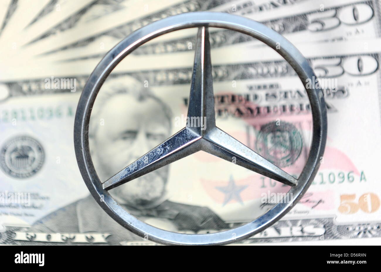 ILLUSTRATION - Dollar bills are pictured behind a Mercedes star in ...