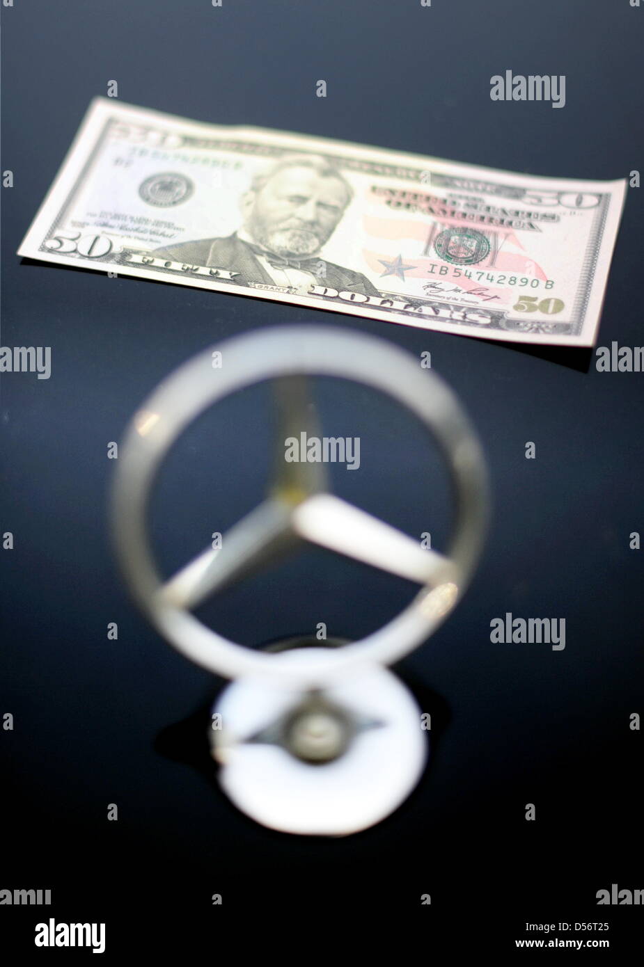 ILLUSTRATION - A Dollar bill placed behind a Mercedes logo in Hamburg ...