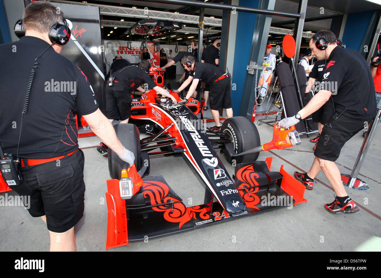 Mechanics of Team Virgin Racing push the car of German Timo Glock back ...