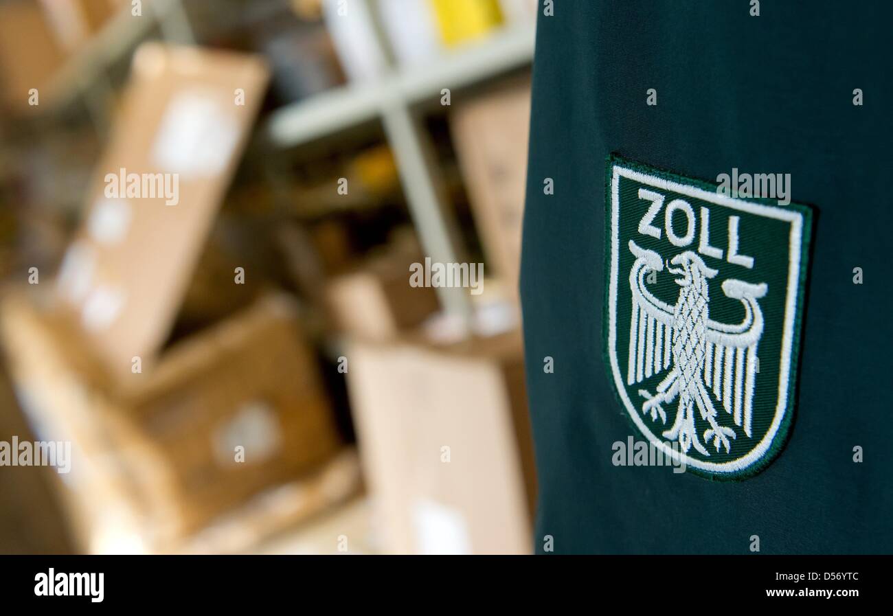 A customs officer stands in front of a shelf filled with boxes during a ...