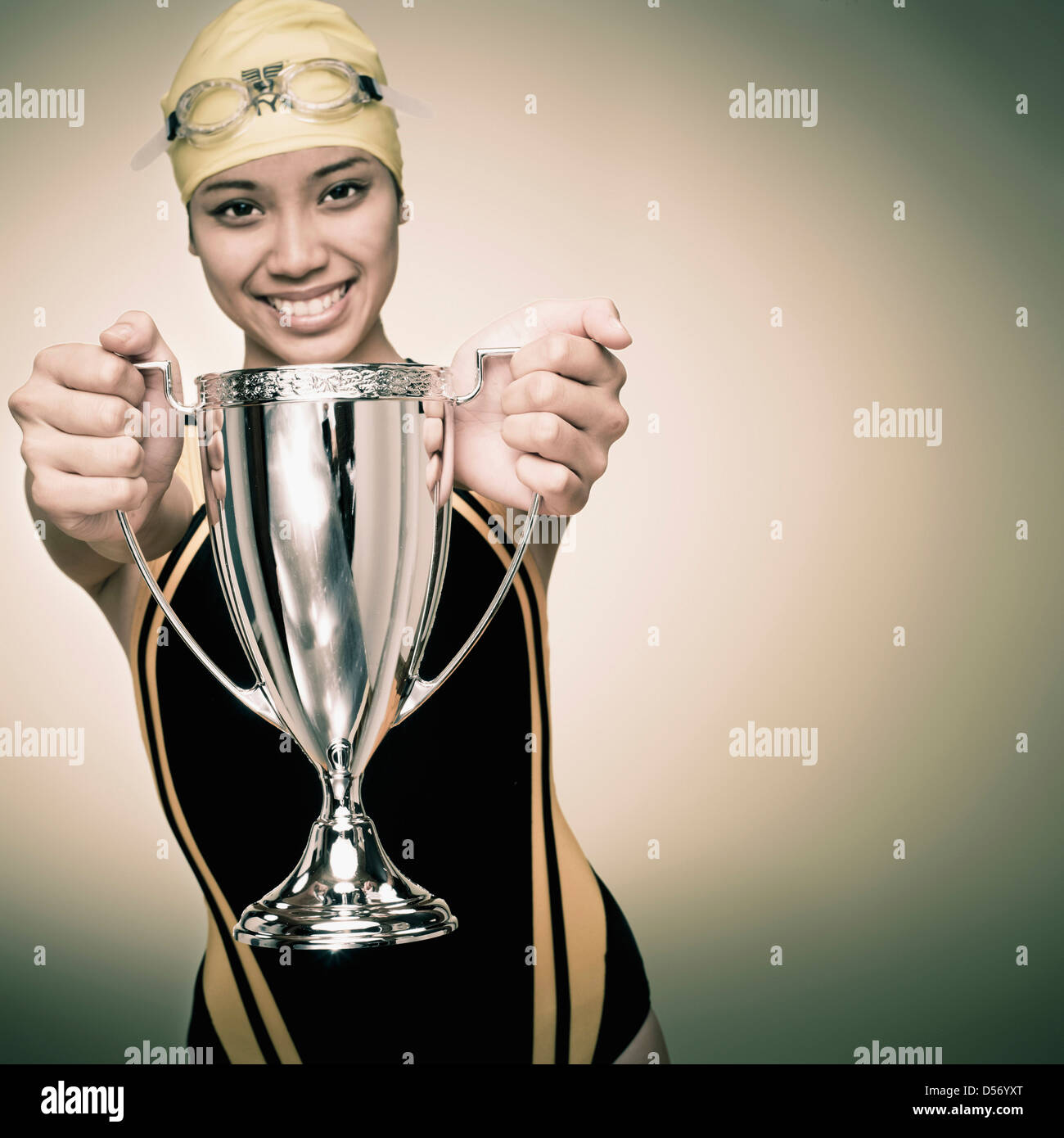 Mixed race swimmer holding trophy Stock Photo - Alamy