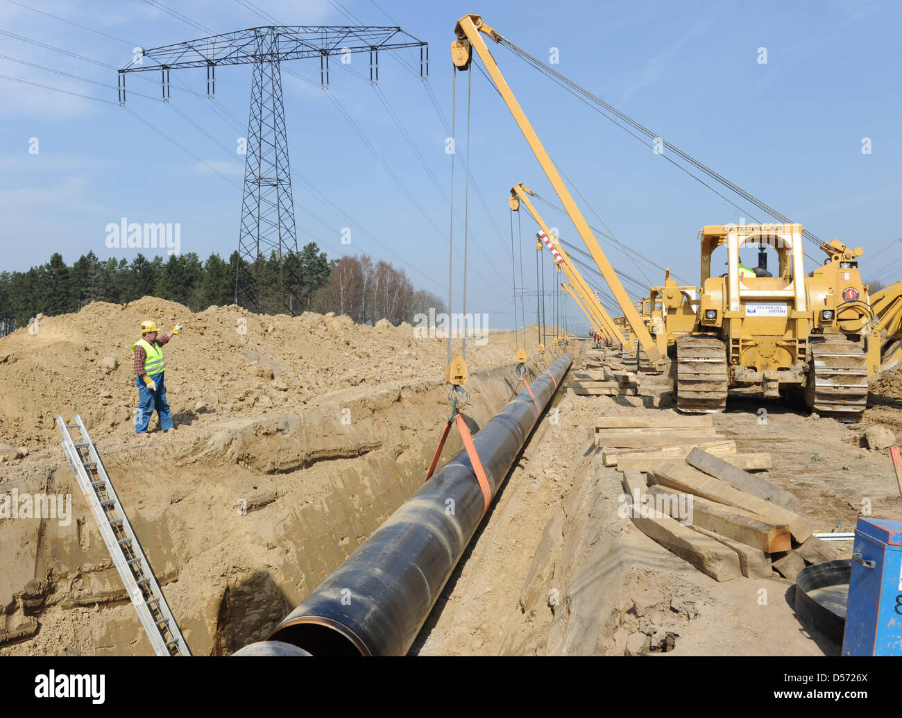 Workers lay a part of OPAL natural gas pipeline near Lubmin, Germany ...