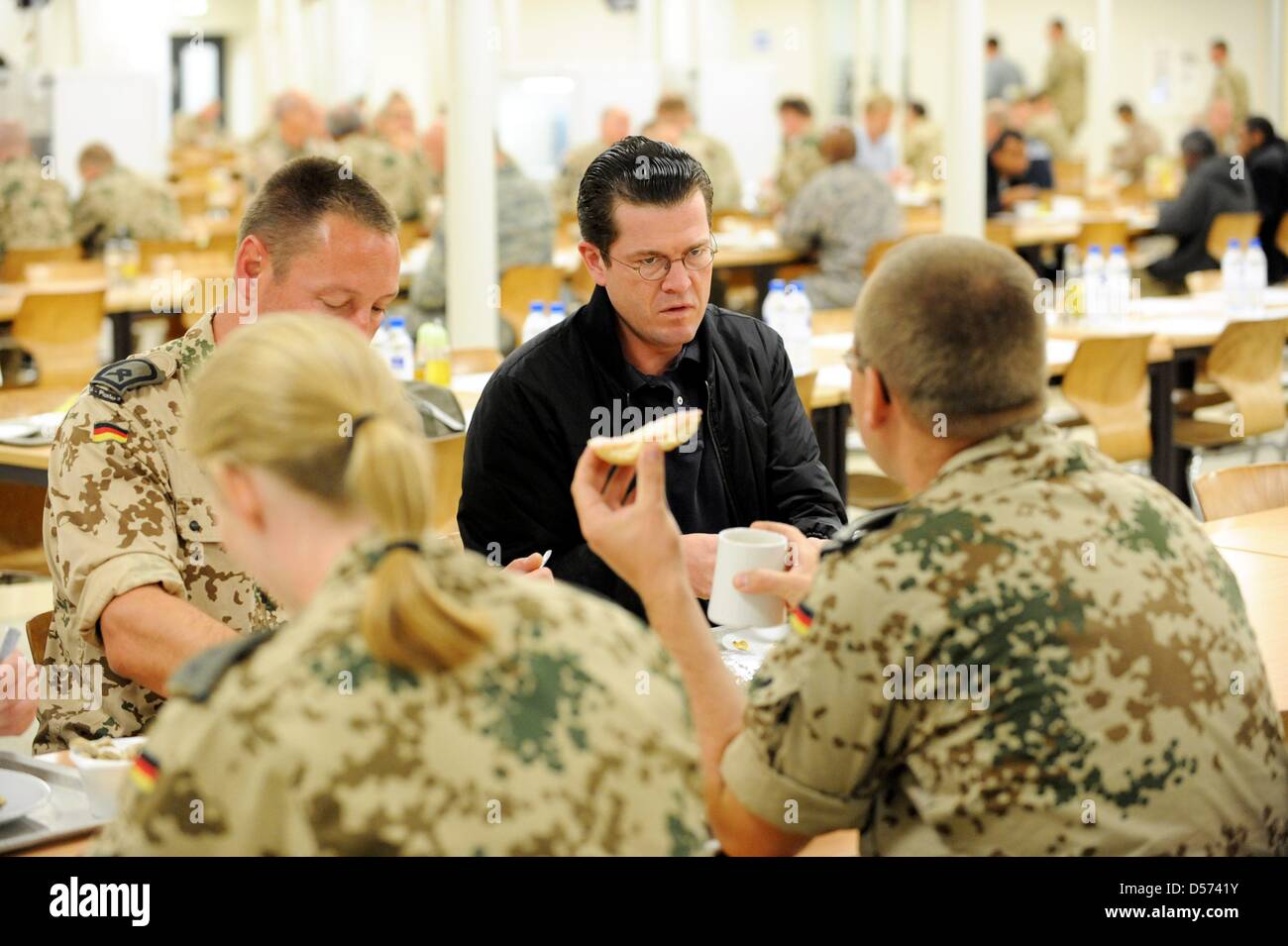 German Minister of Defence Karl-Theodor zu Guttenberg (C) eats ...