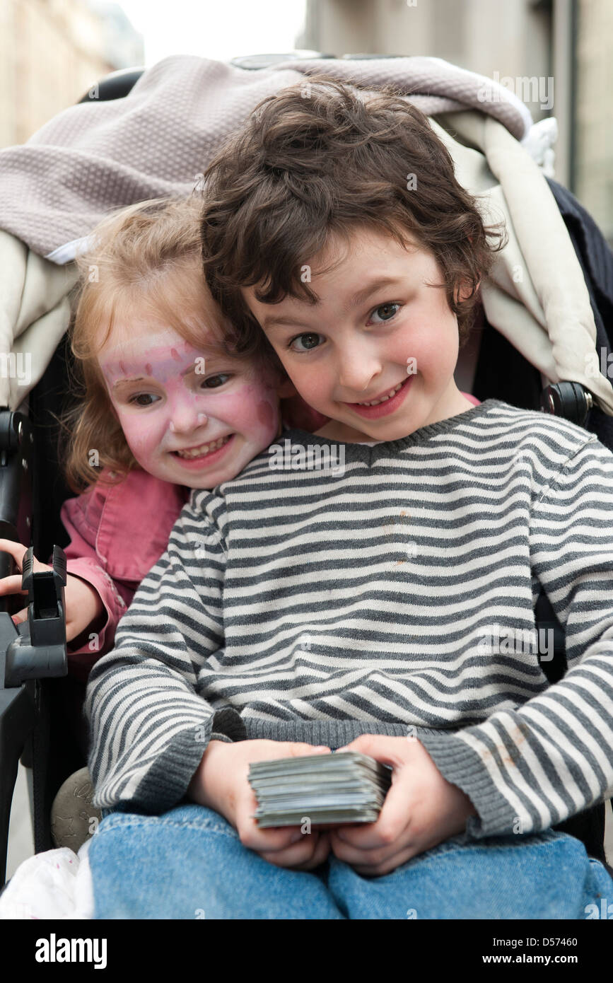 Young siblings sitting together in stroller, portrait Stock Photo - Alamy