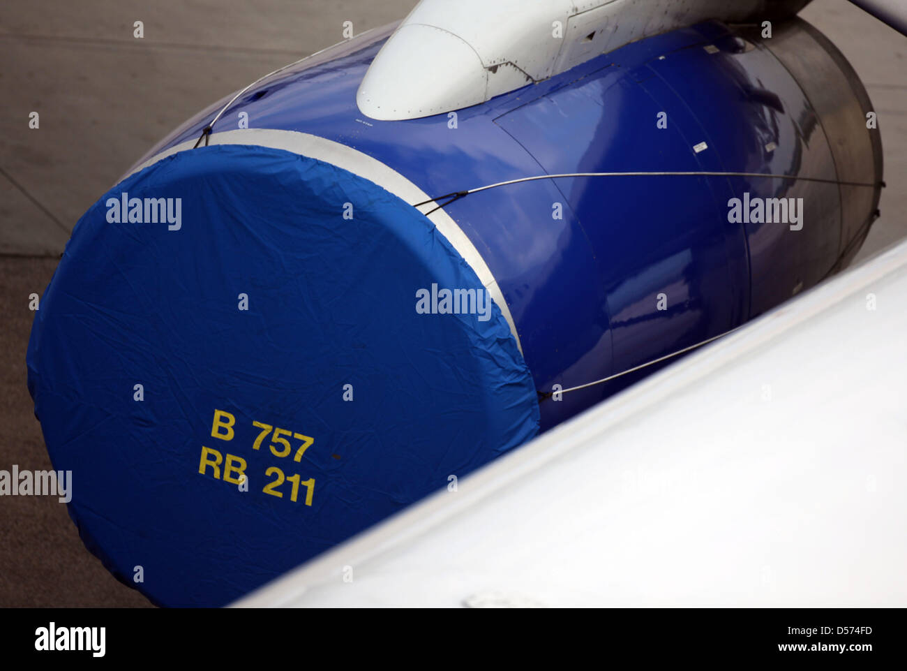 An aeroplane with covered engines stands on the ground at the airport ...