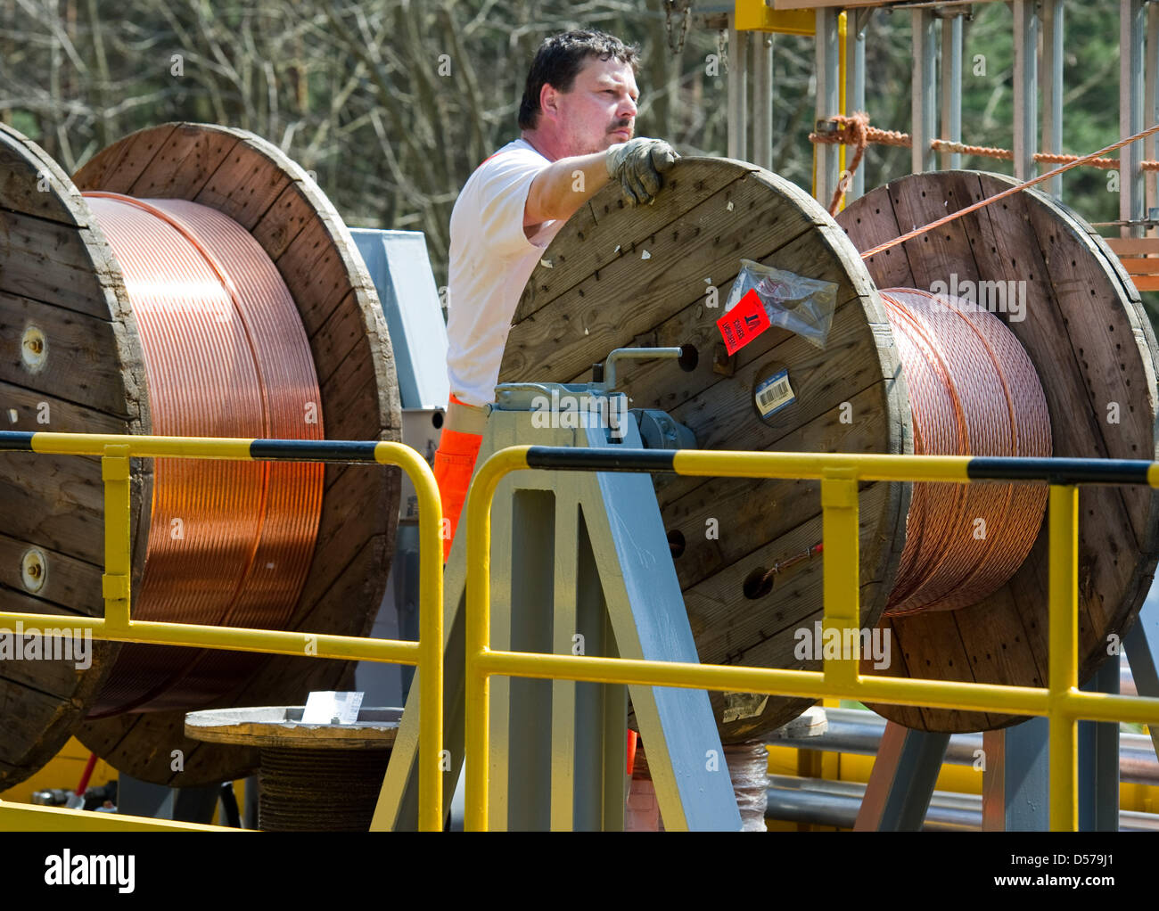 A technicians of Deutsche Bahn installs new copper cables at the tracks ...