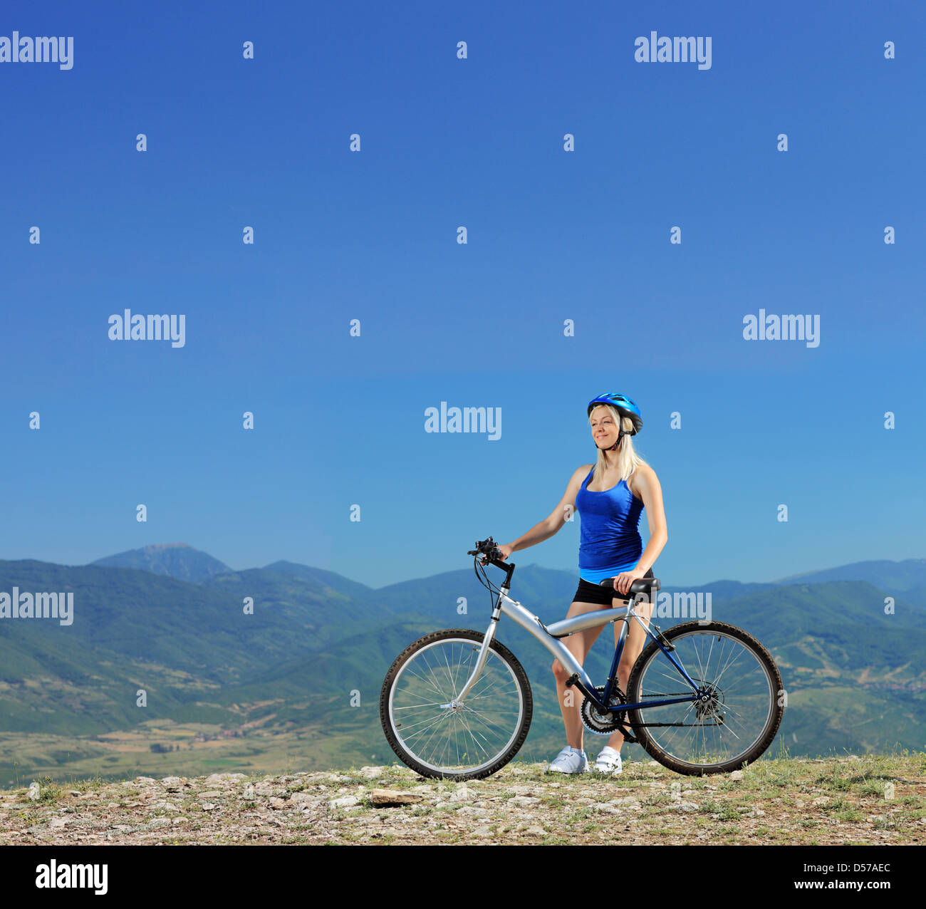 A young female biker posing with a mountain bike outdoors Stock Photo ...