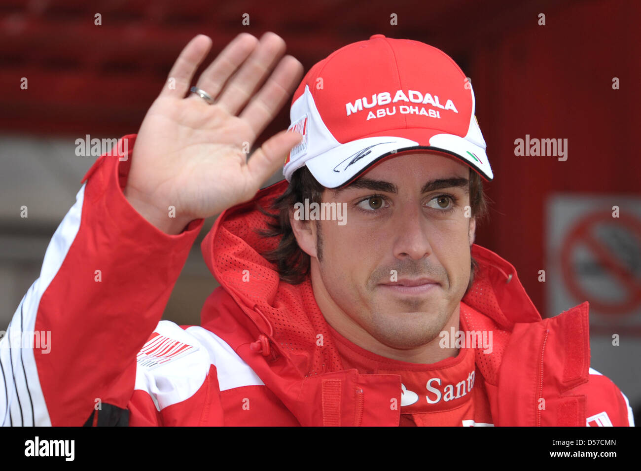 Spanish driver Fernando Alonso of Ferrari waves to fans in the paddock ...