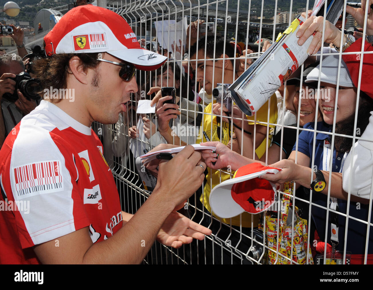 Spanish driver Fernando Alonso of Ferrari signs autographs at the ...
